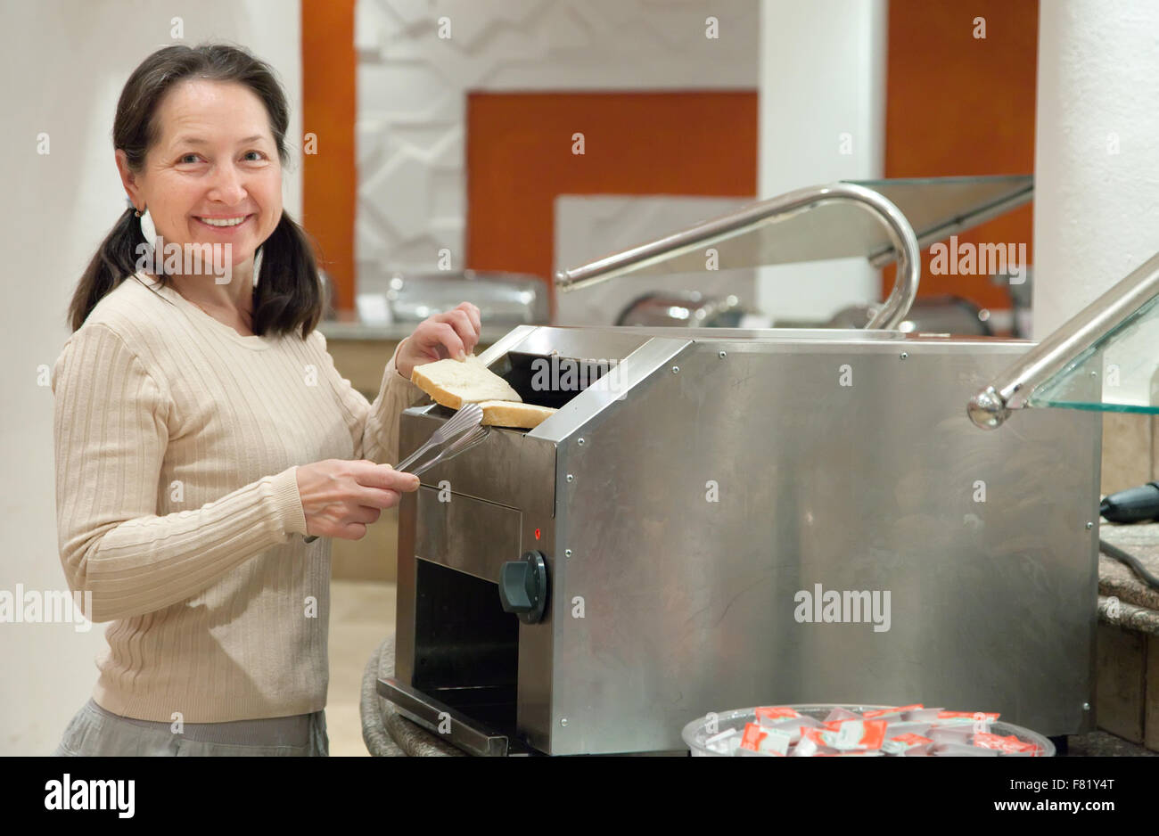 woman makes toast in a toaster at hotel restaurant Stock Photo - Alamy