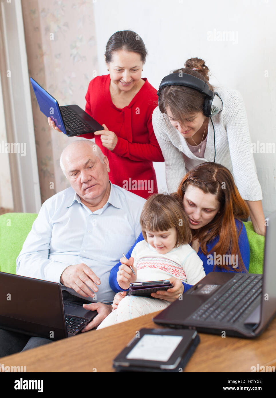Happy multigeneration family uses few various electronic devices Stock ...