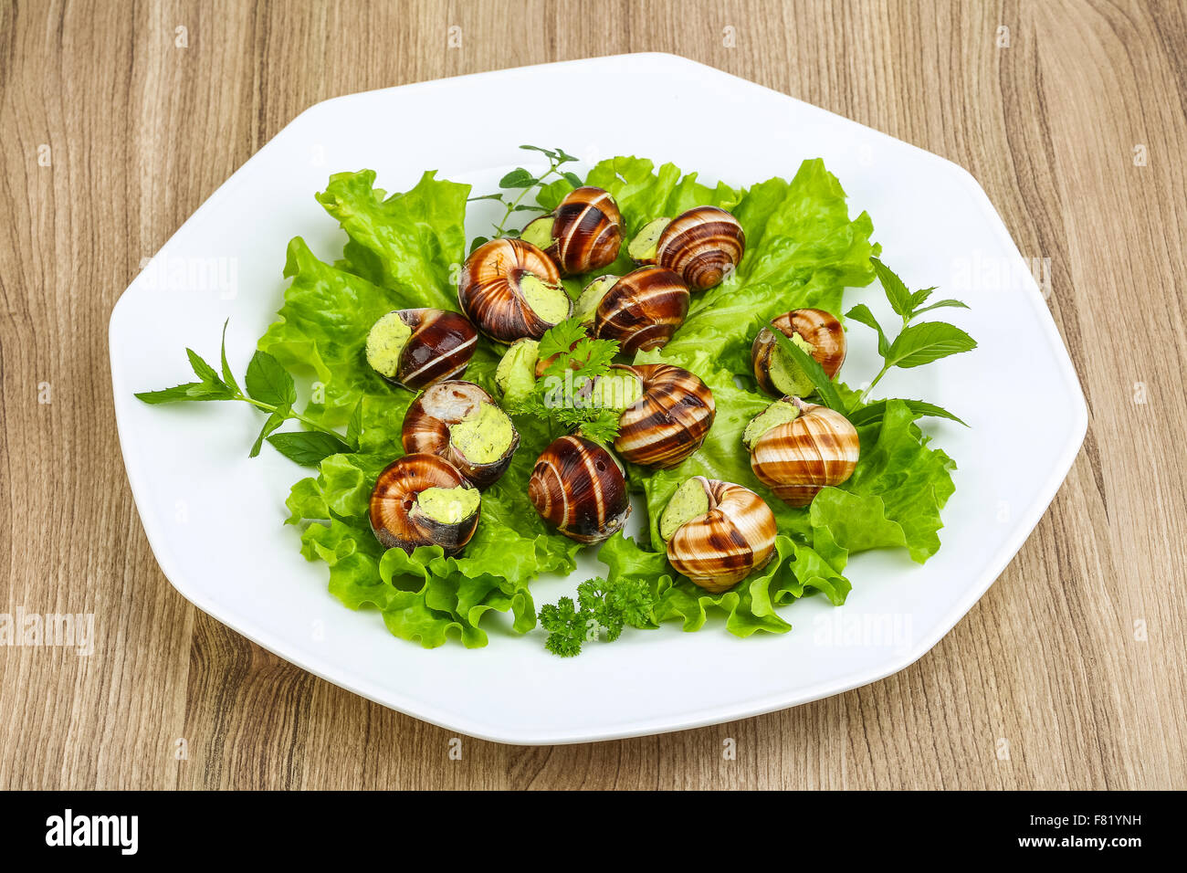 Escargot with parsley butter - served salad and mint leaves Stock Photo ...