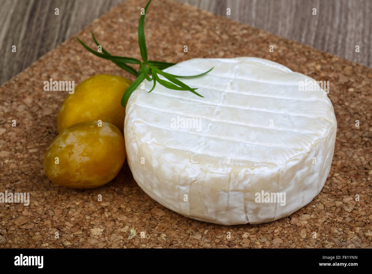 Round Brie cheese with yellow plums and estragon Stock Photo - Alamy