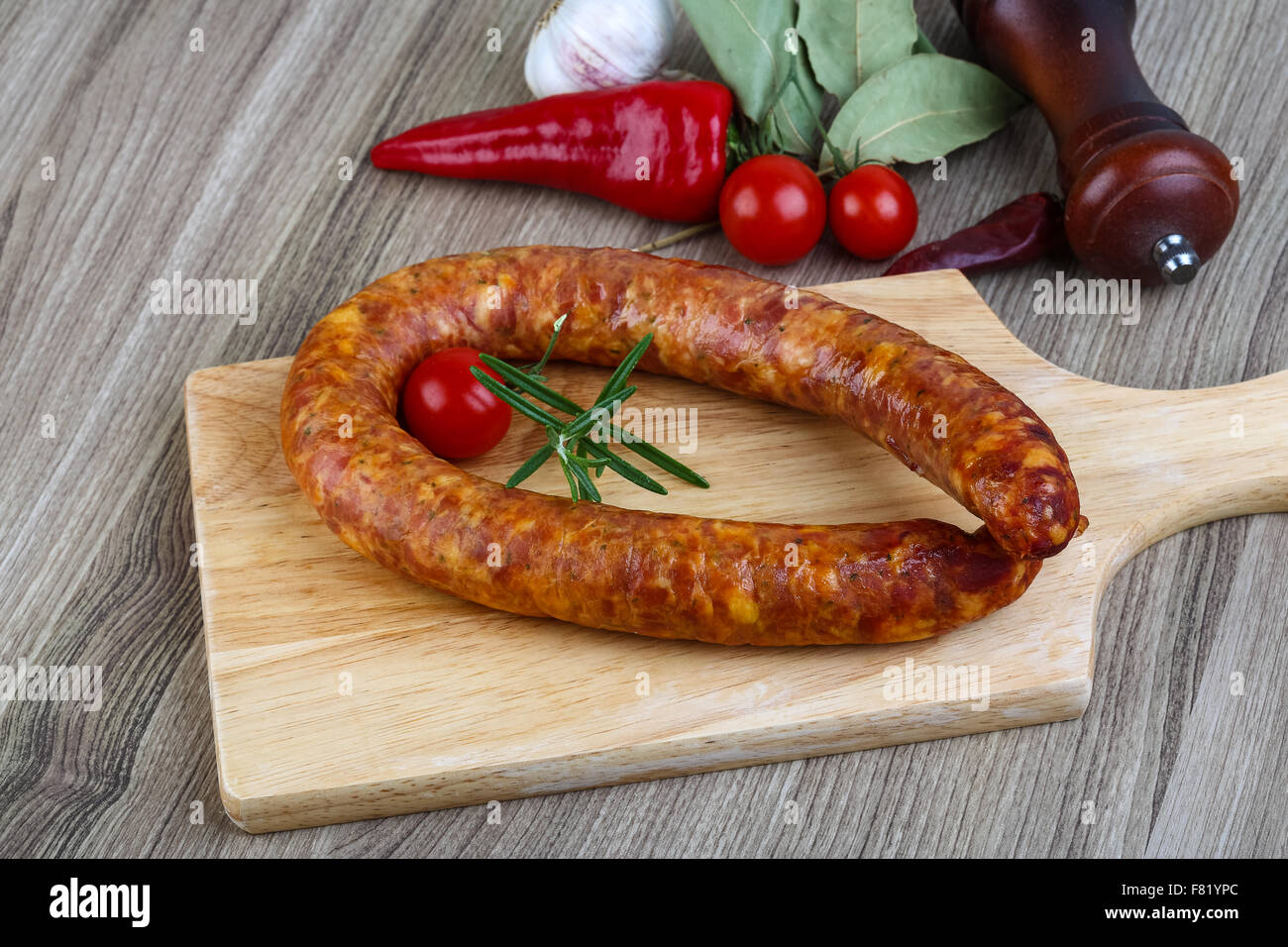 Sausage ring with rosemary and pepper on the wood background Stock ...
