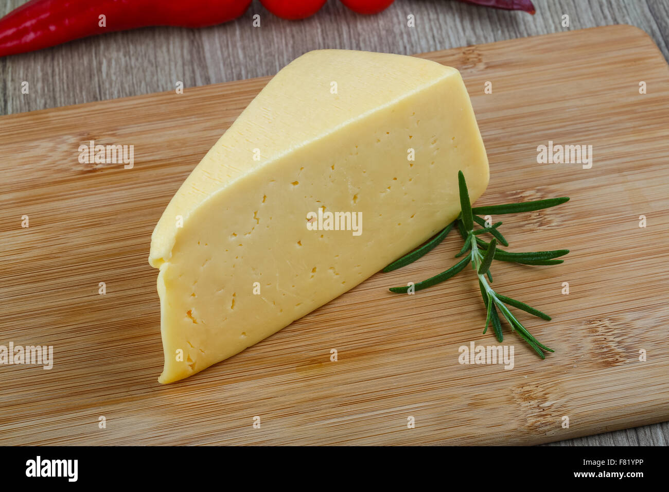 Yellow cheese triangle with rosemary herbs on the wood background Stock ...