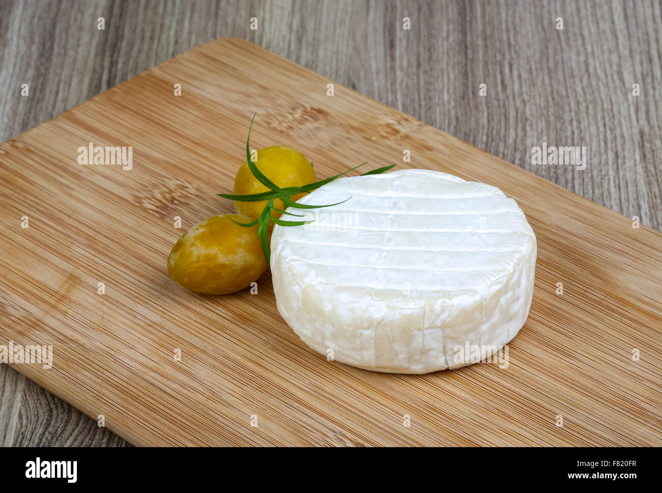 Round Brie cheese with yellow plums and estragon Stock Photo - Alamy