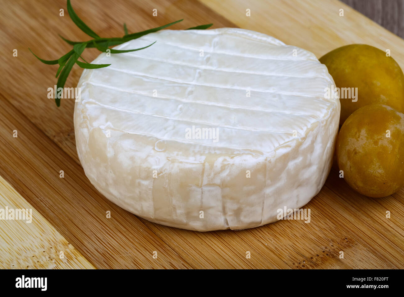 Round Brie cheese with yellow plums and estragon Stock Photo - Alamy