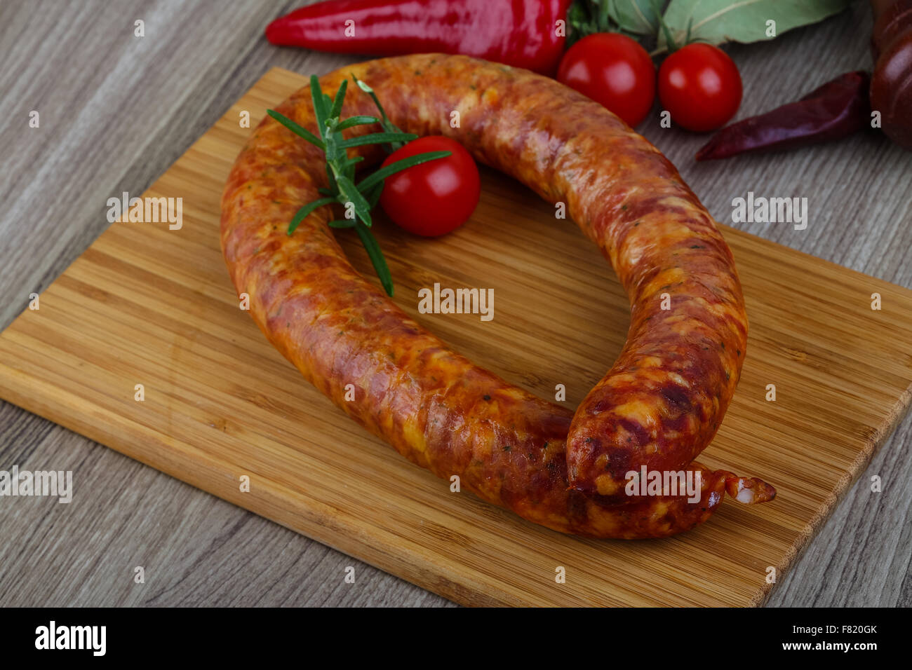 Sausage ring with rosemary and pepper on the wood background Stock ...