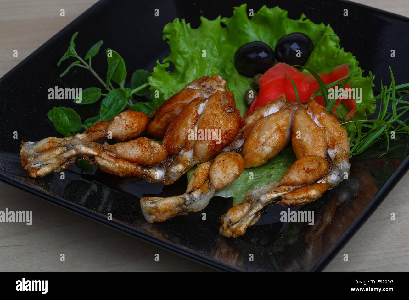 Roasted Frog legs with herbs and spices Stock Photo - Alamy