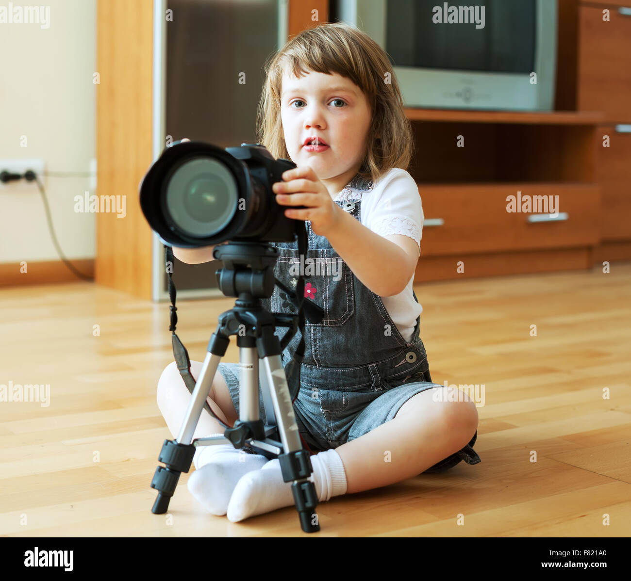 child takes photo with camera and tripod in home Stock Photo - Alamy