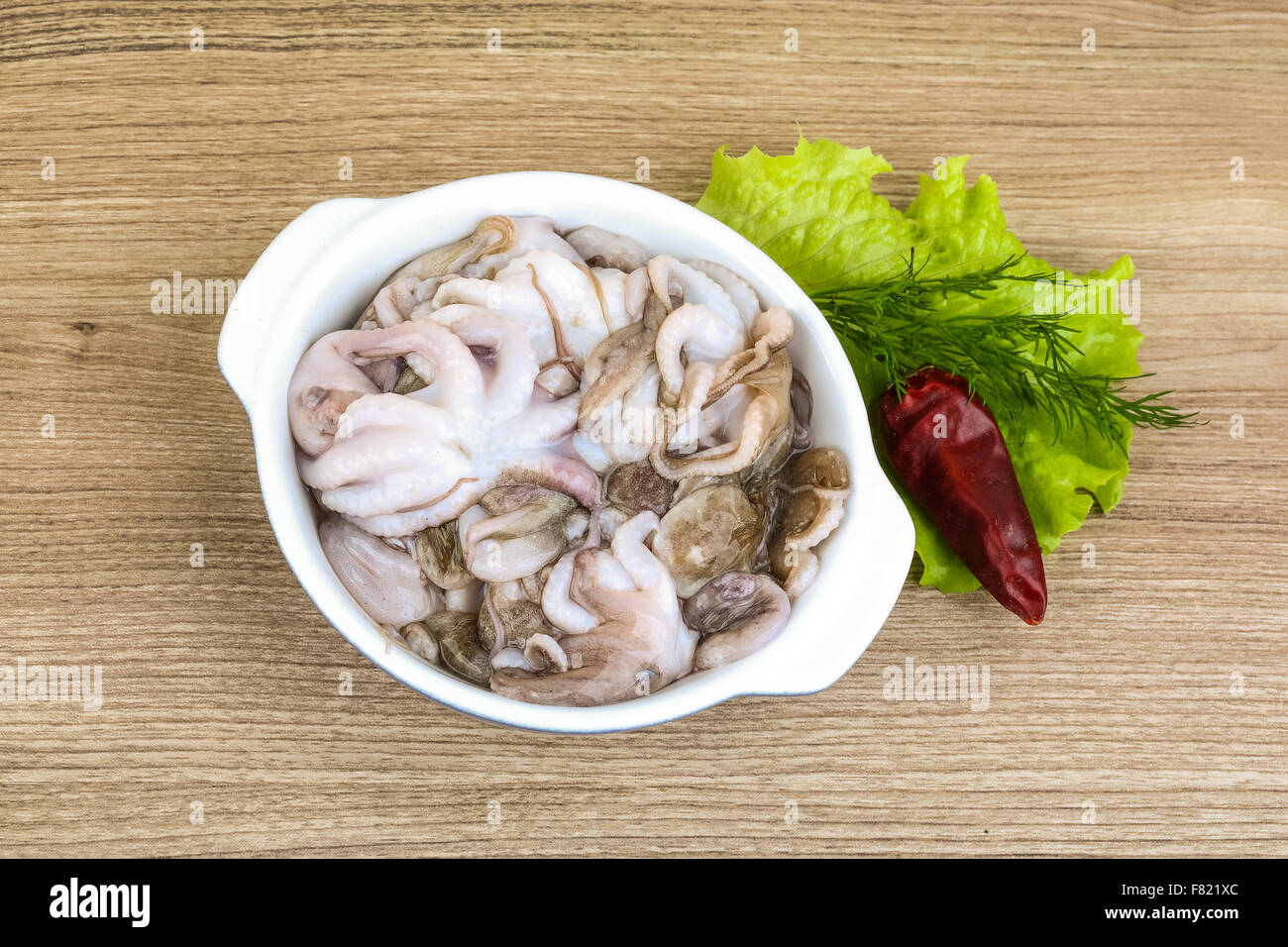 Raw baby octopus in the bowl ready for cooking Stock Photo - Alamy