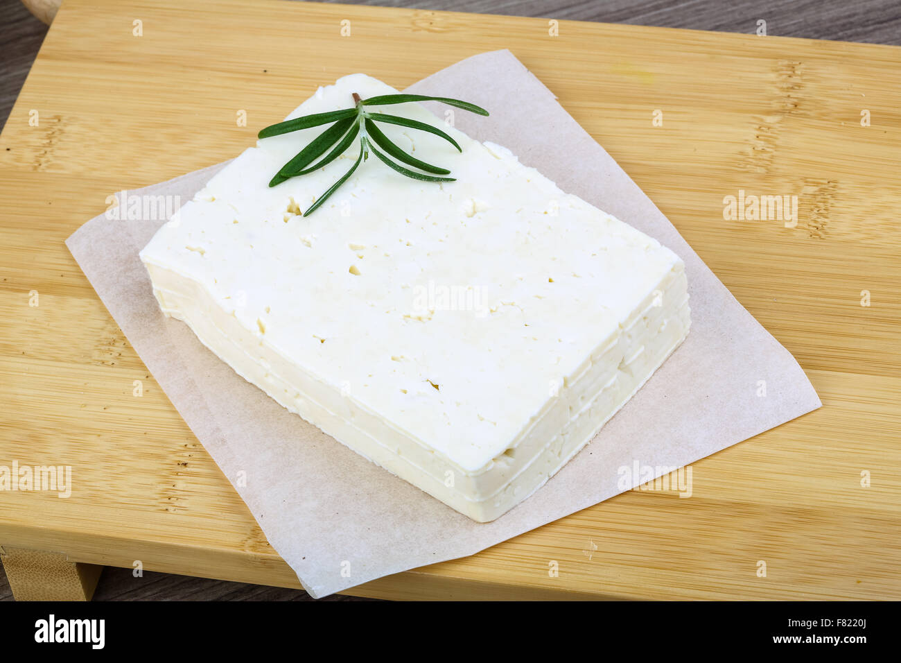 White bulgarian cheese brinza with rosemary on the wood background ...