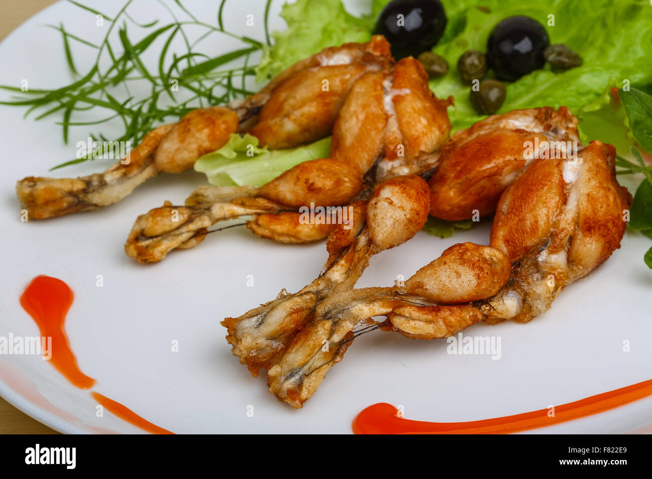 Fried frog legs with herbs on the wood background Stock Photo - Alamy