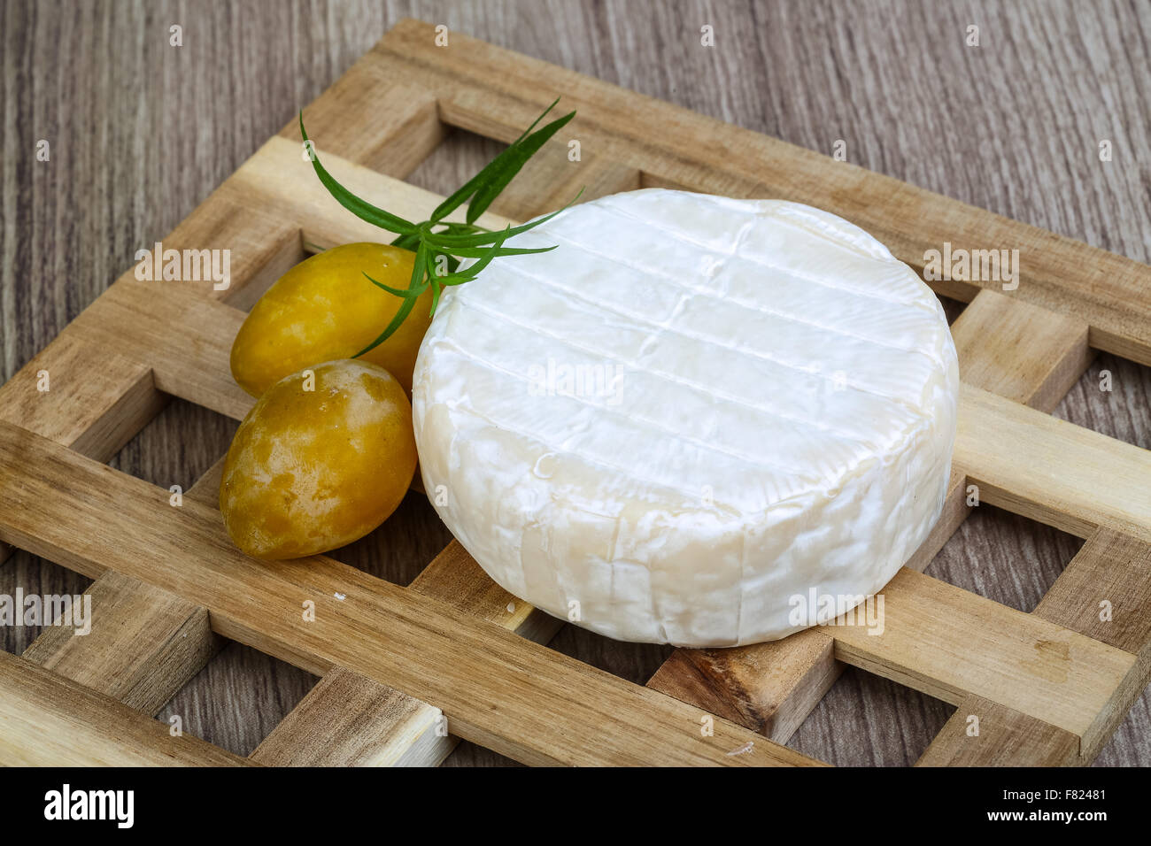 Round Brie cheese with yellow plums and estragon Stock Photo - Alamy