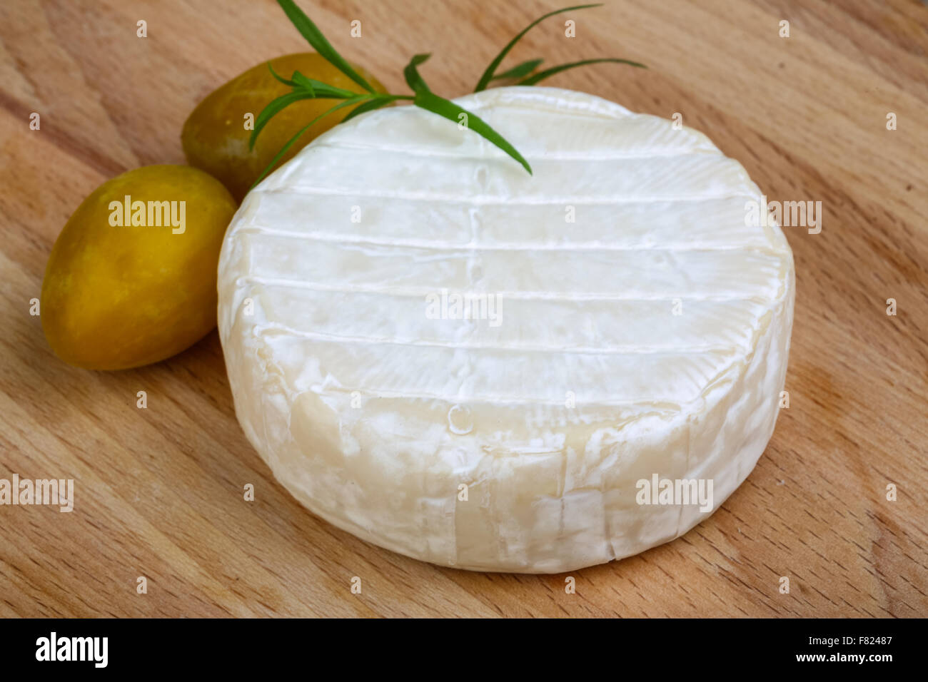 Round Brie cheese with yellow plums and estragon Stock Photo - Alamy