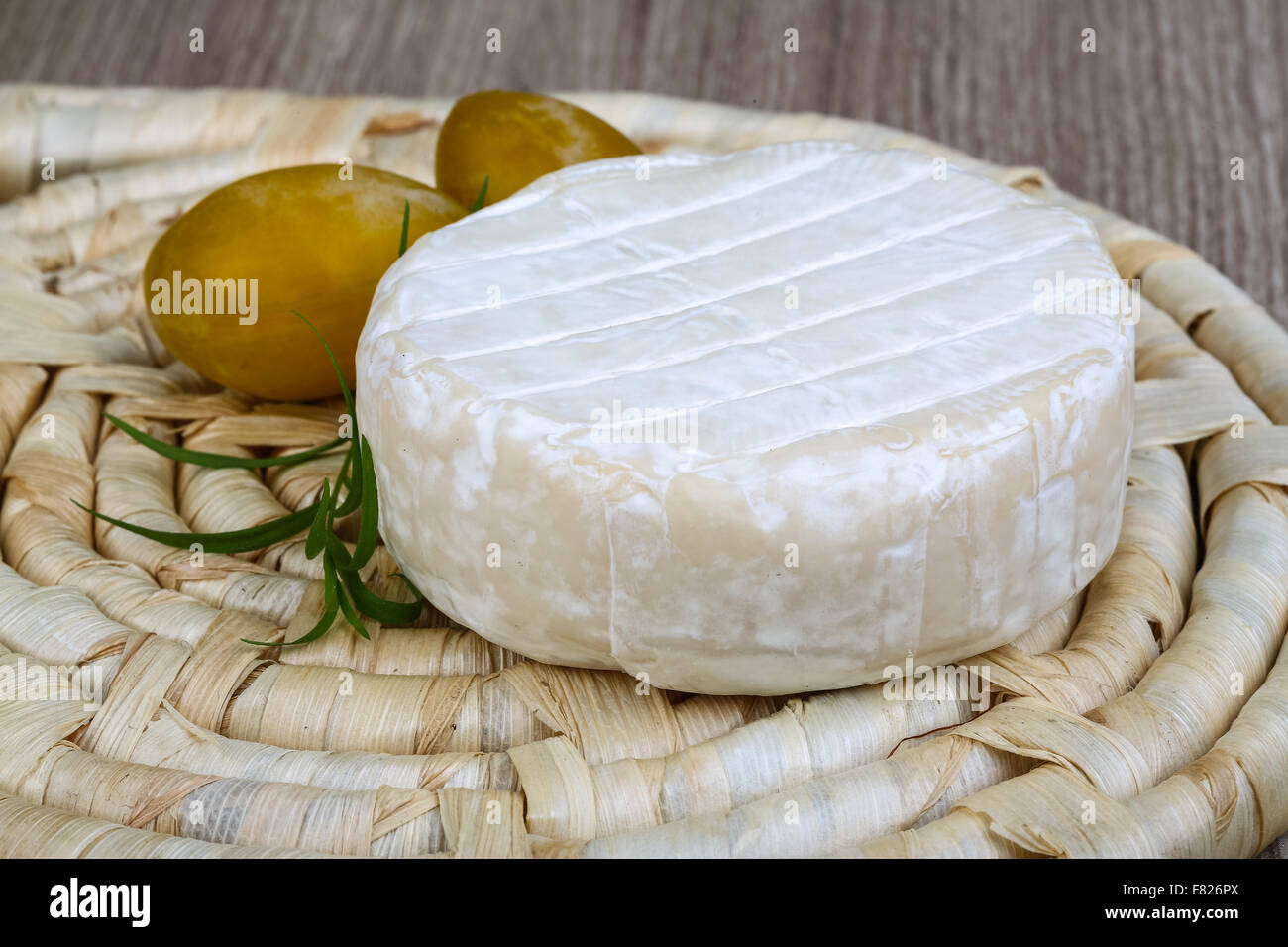 Round Brie cheese with yellow plums and estragon Stock Photo - Alamy