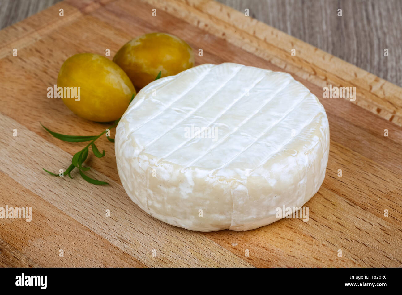 Round Brie cheese with yellow plums and estragon Stock Photo - Alamy