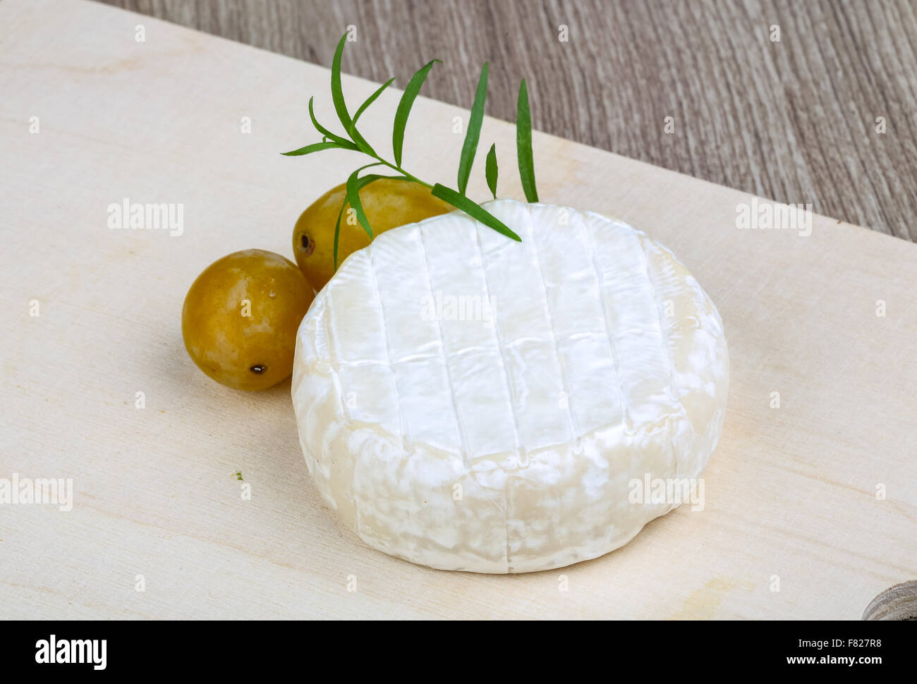 Round Brie cheese with yellow plums and estragon Stock Photo - Alamy