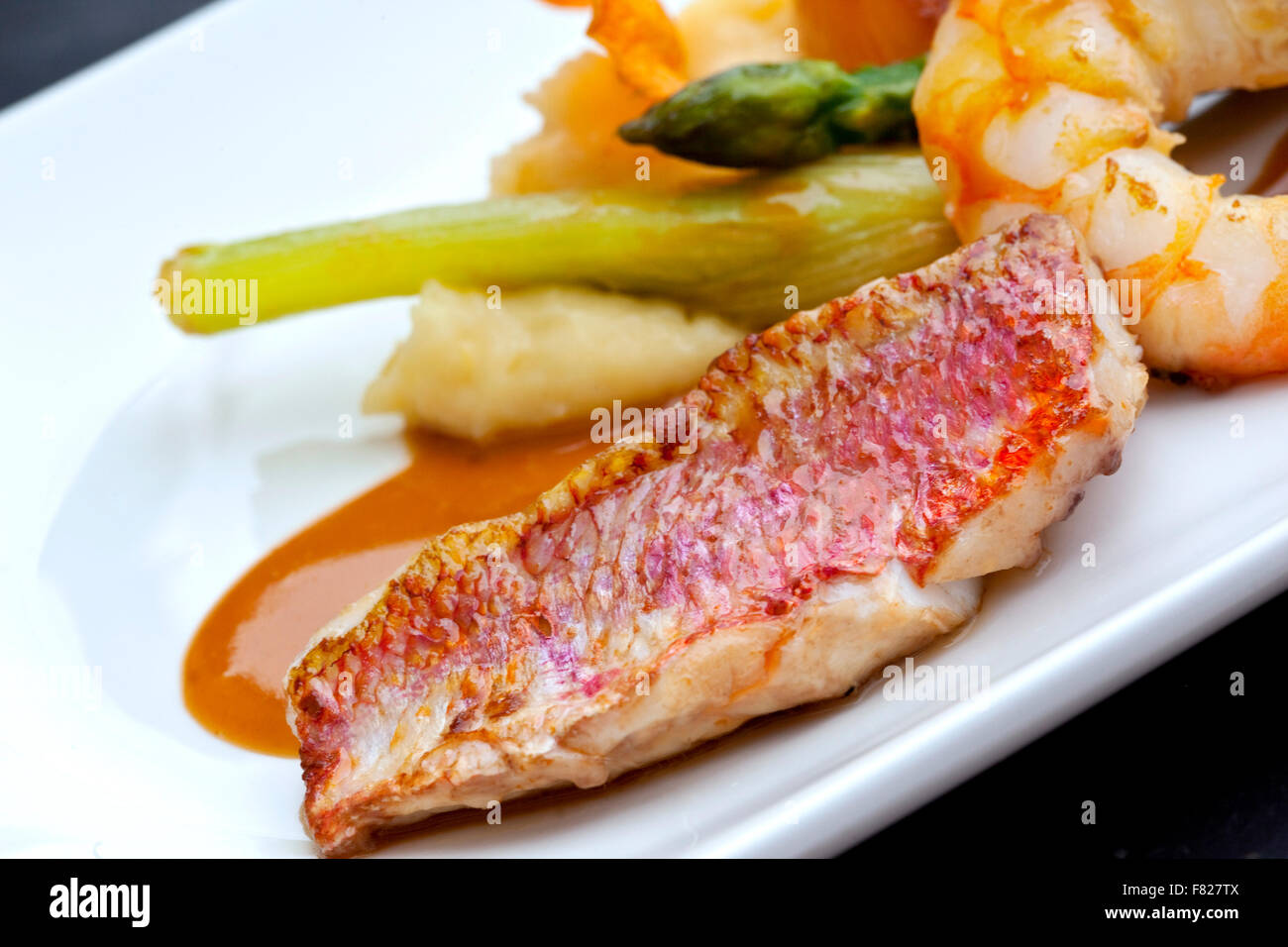 Red mullet fillet, asparagus, shrimp, puree and celery on a plate Stock ...