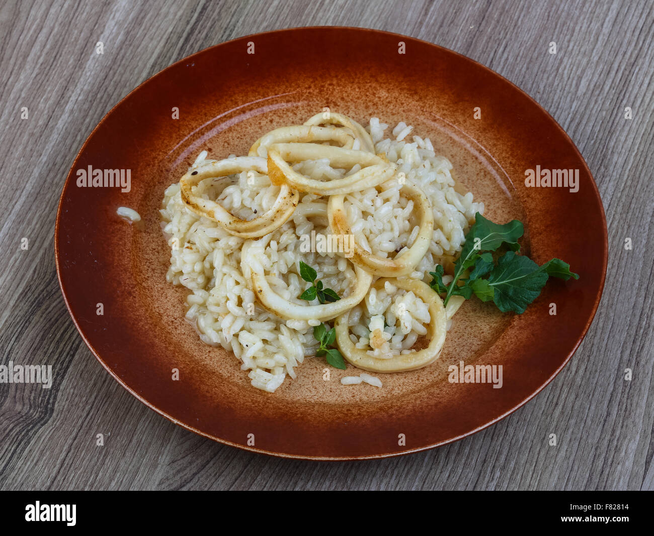 Italian famous cuisine - Squid risotto served basil leaves Stock Photo ...
