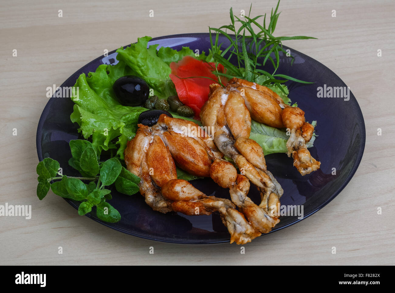 Roasted Frog legs with herbs and spices Stock Photo - Alamy
