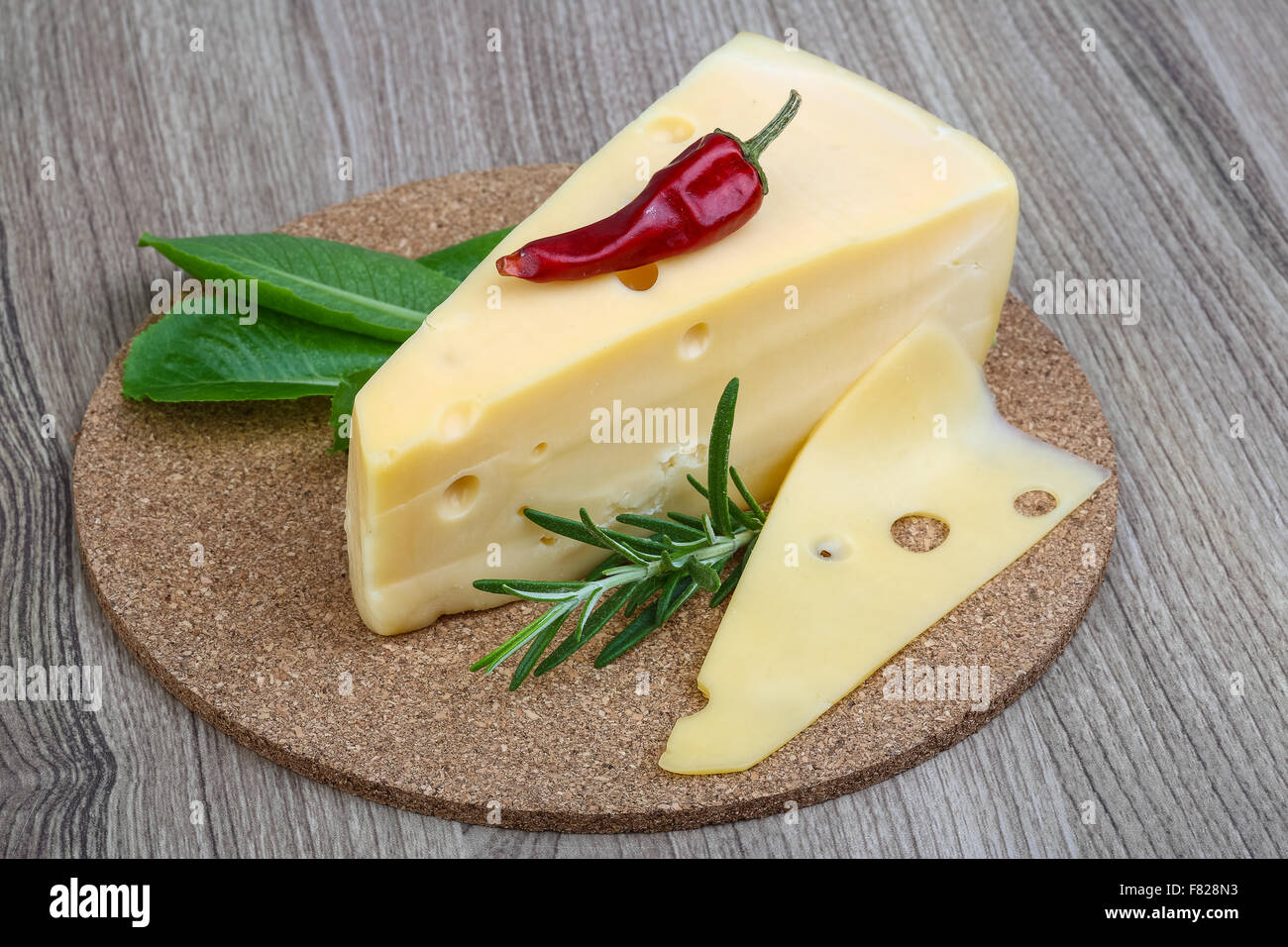 Triangle yellow cheese with rosemary, pepper and salad leaves Stock ...