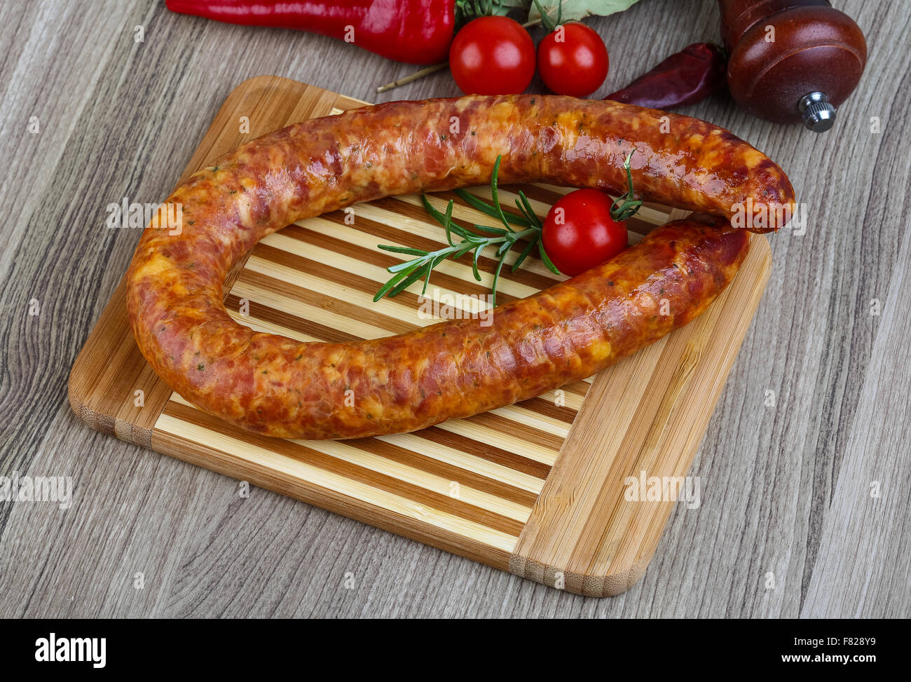 Sausage ring with rosemary and pepper on the wood background Stock ...
