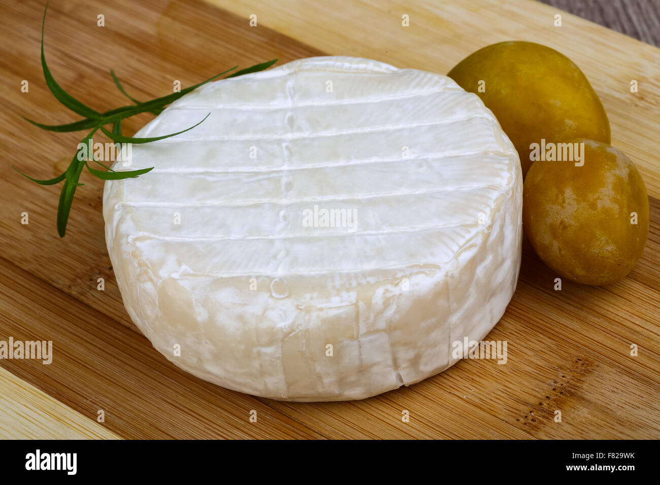 Round Brie cheese with yellow plums and estragon Stock Photo - Alamy