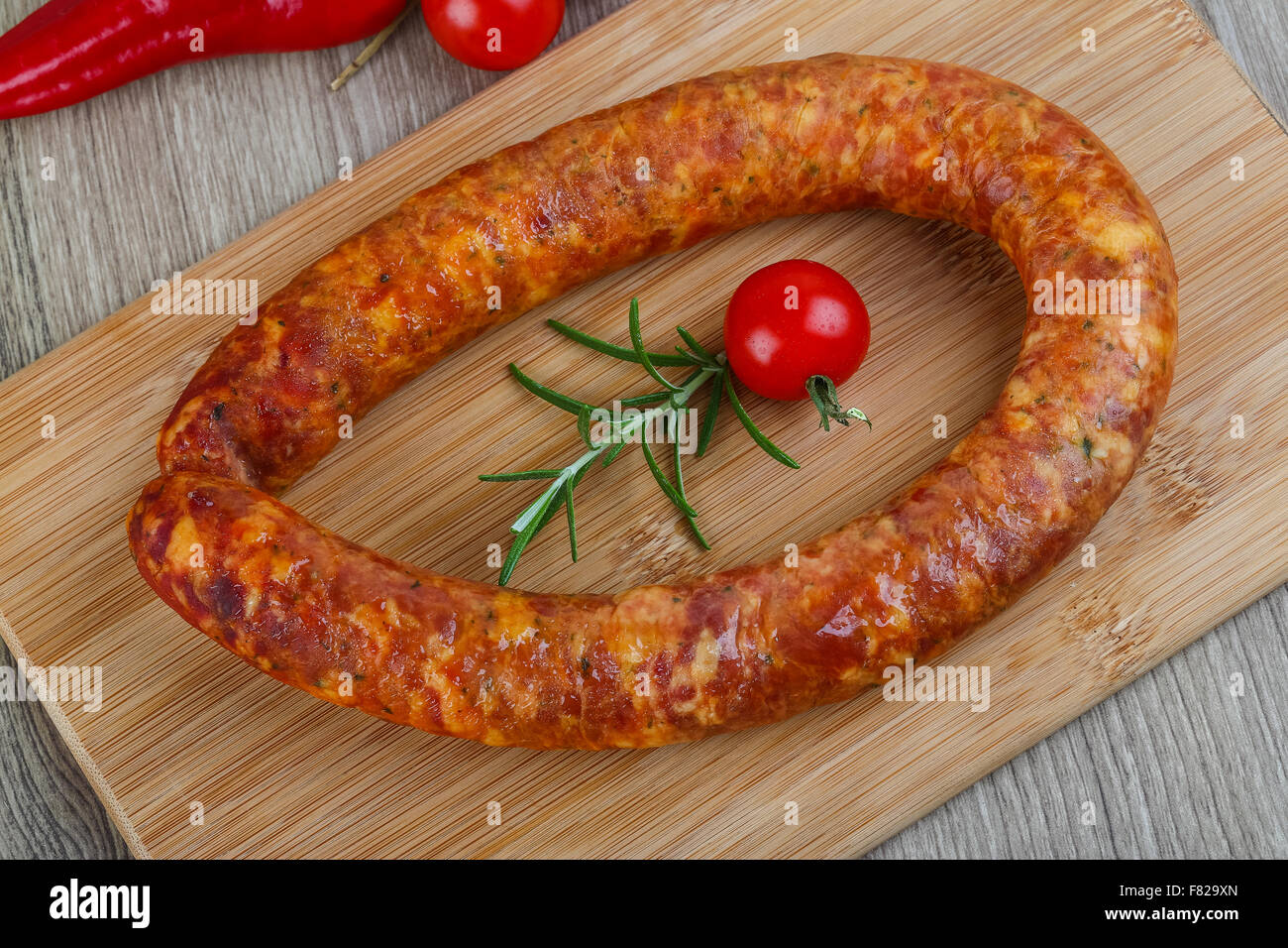 Sausage ring with rosemary and pepper on the wood background Stock ...