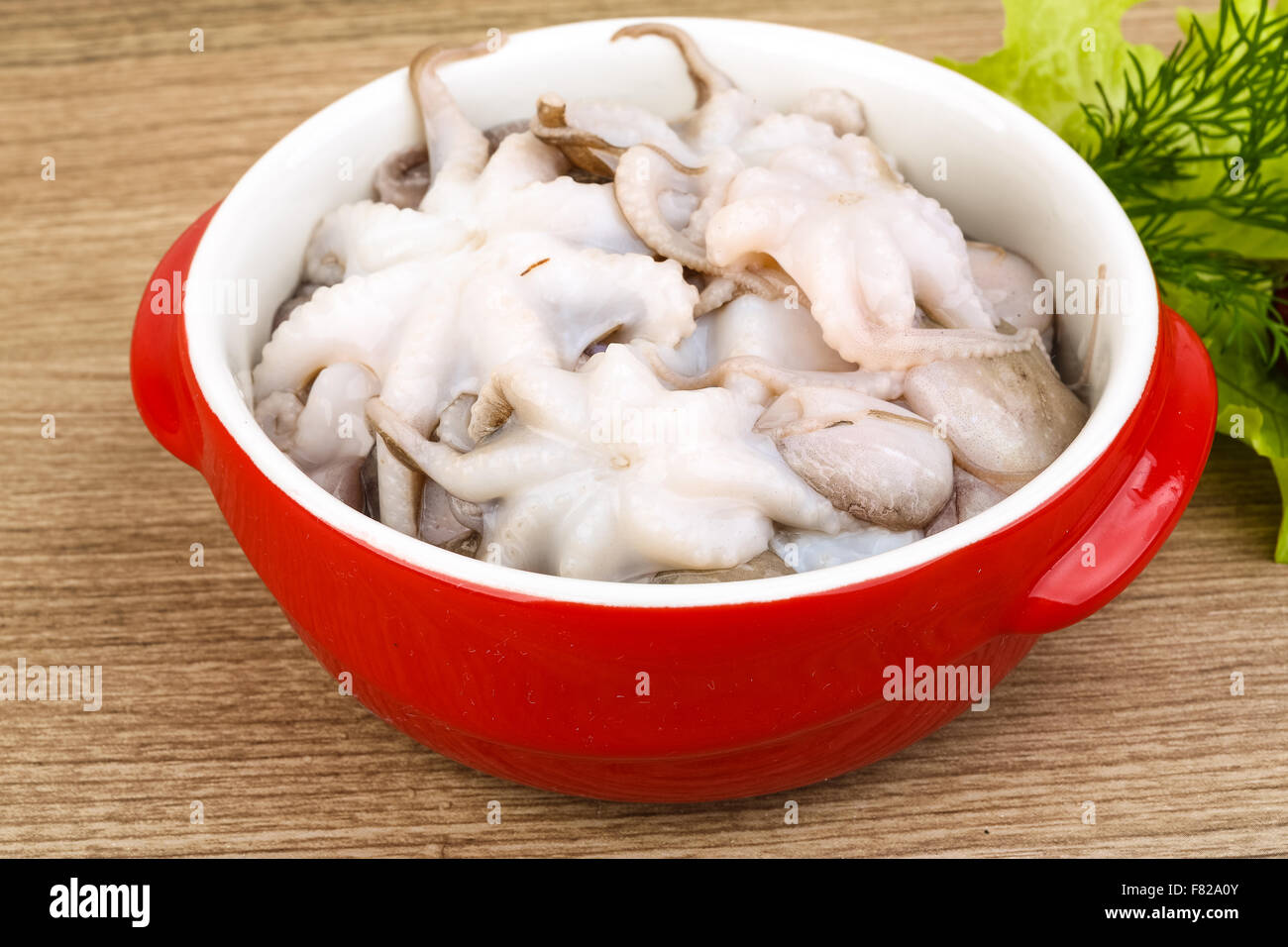 Raw baby octopus in the bowl ready for cooking Stock Photo - Alamy
