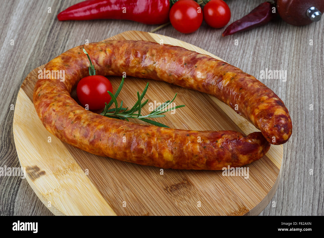Sausage ring with rosemary and pepper on the wood background Stock ...