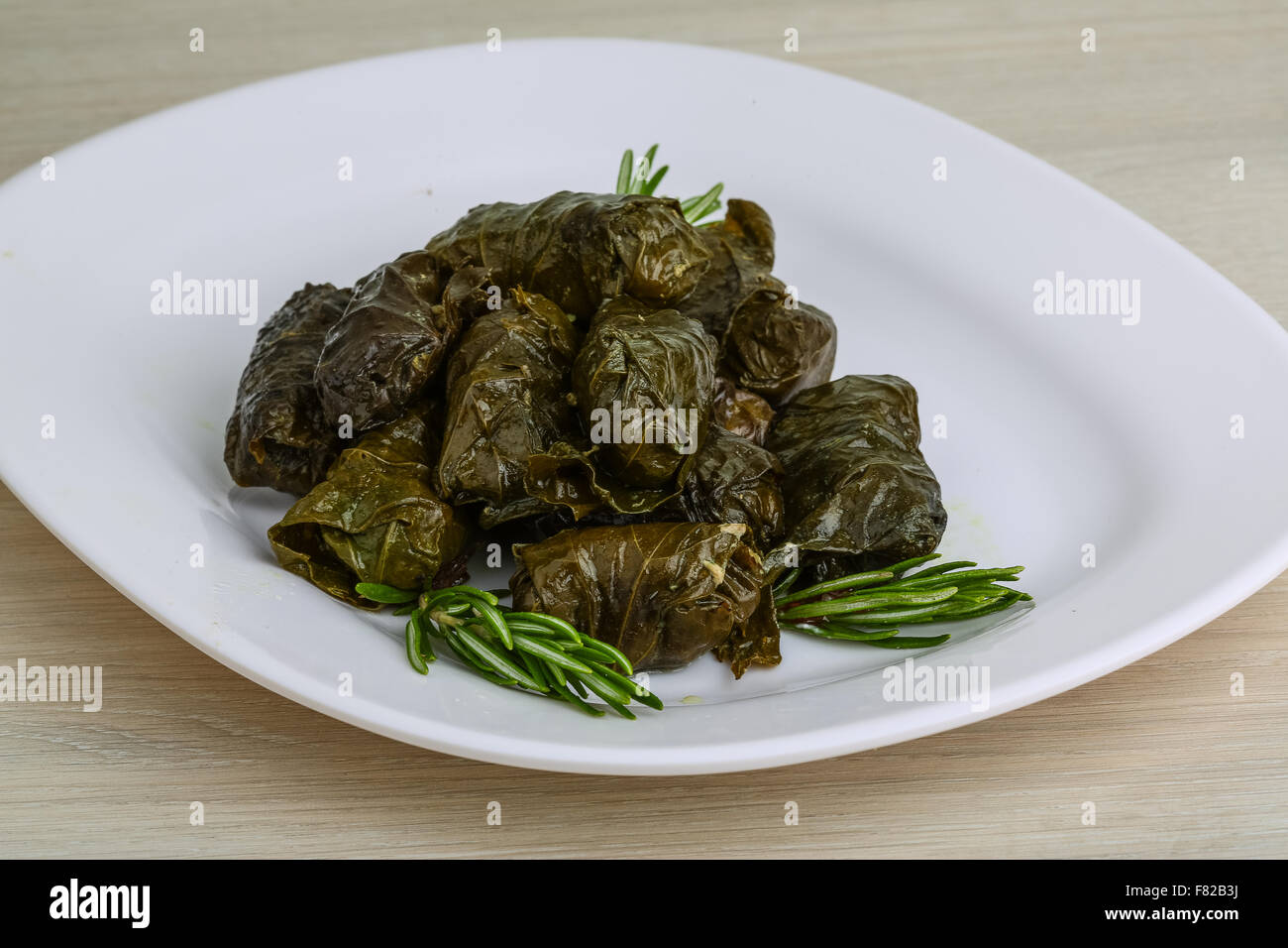 Greek dolma in grape leaves with meat served rosemary Stock Photo - Alamy