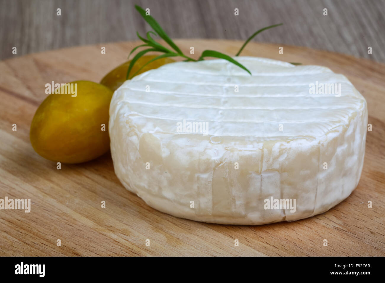 Round Brie cheese with yellow plums and estragon Stock Photo - Alamy