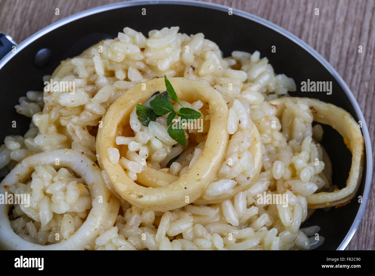 Italian famous cuisine - Squid risotto served basil leaves Stock Photo ...