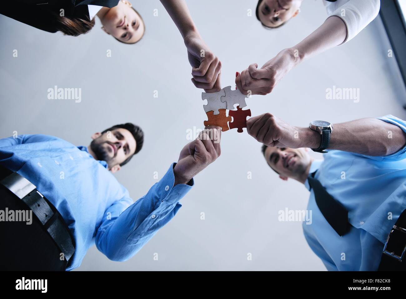 Group of business people assembling jigsaw puzzle and represent team ...