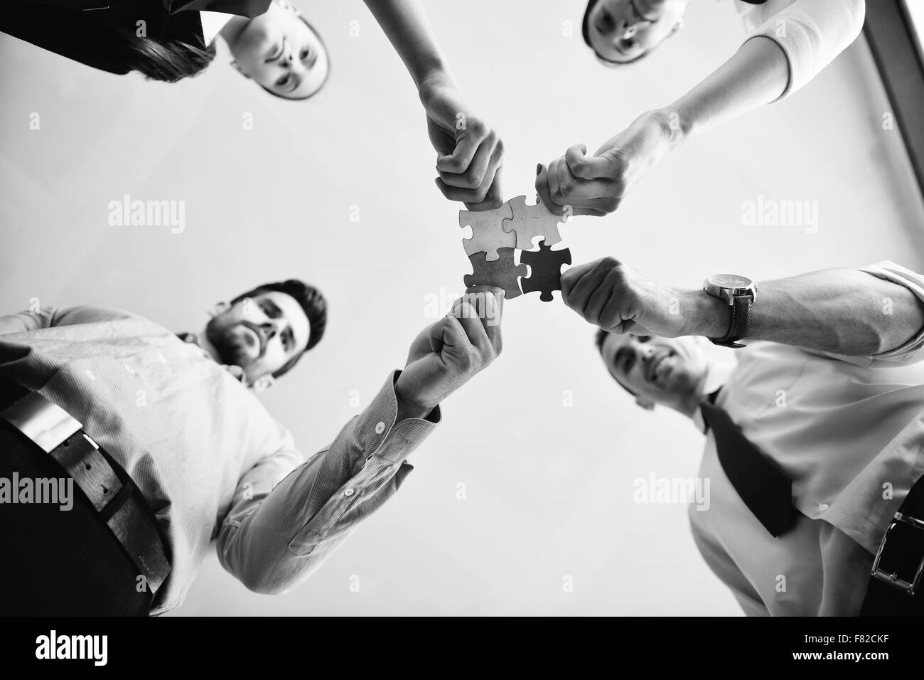 Group of business people assembling jigsaw puzzle and represent team ...