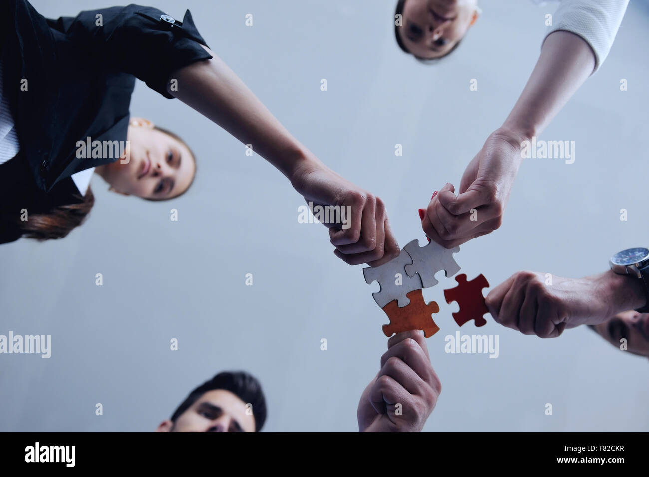 Group of business people assembling jigsaw puzzle and represent team ...