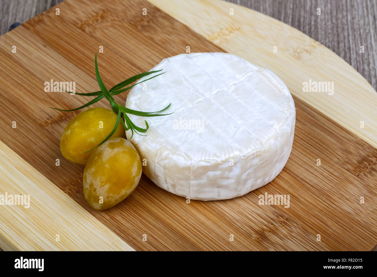 Round Brie cheese with yellow plums and estragon Stock Photo - Alamy