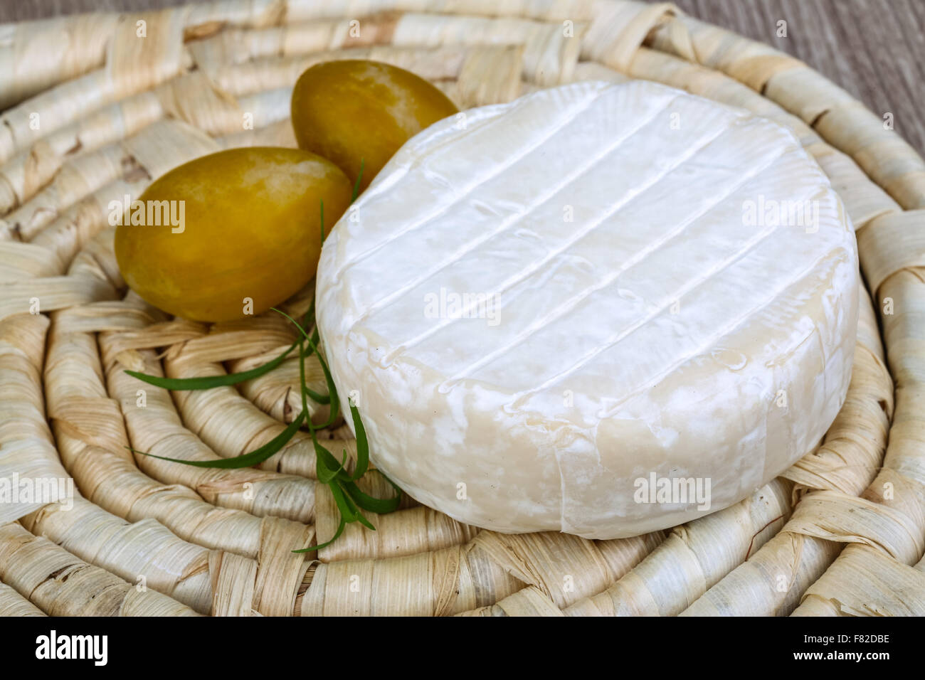 Round Brie cheese with yellow plums and estragon Stock Photo - Alamy