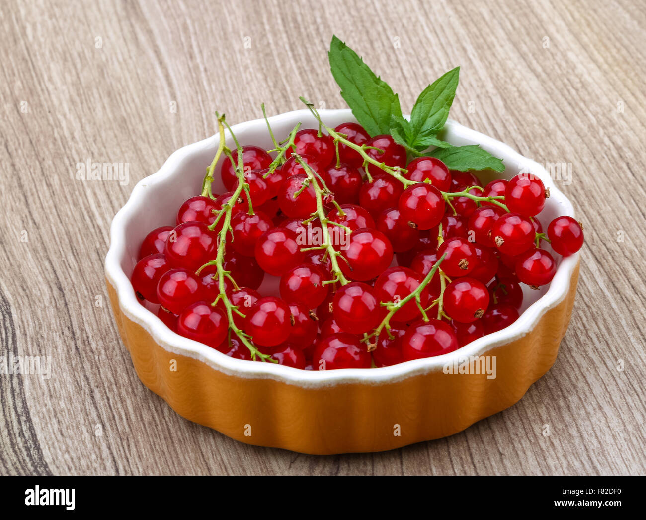 Fresh bright Red currant on the wood background with mint leaves Stock ...