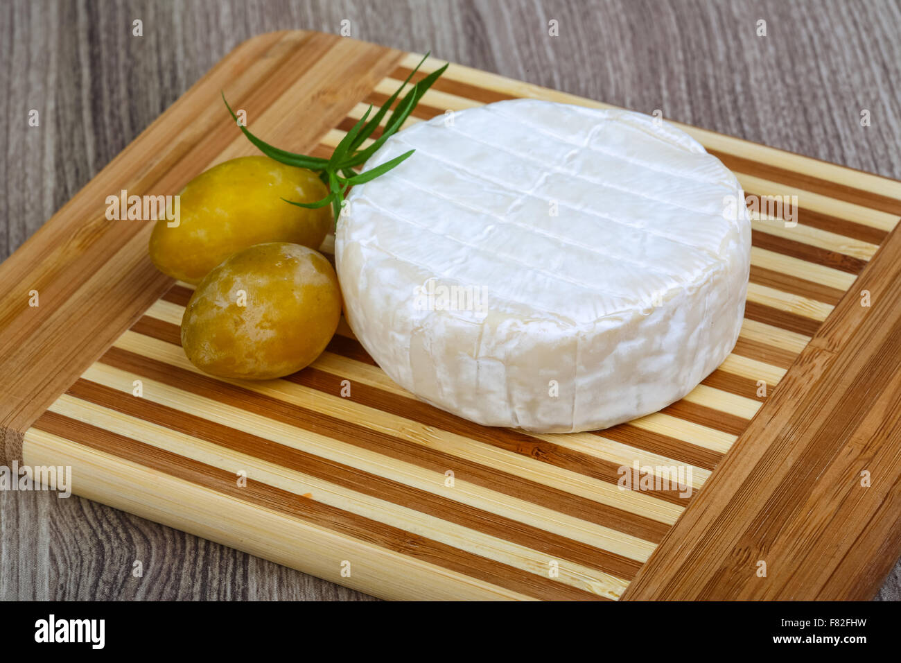 Round Brie cheese with yellow plums and estragon Stock Photo - Alamy