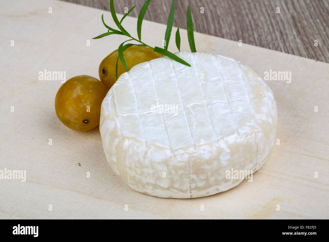 Round Brie cheese with yellow plums and estragon Stock Photo - Alamy