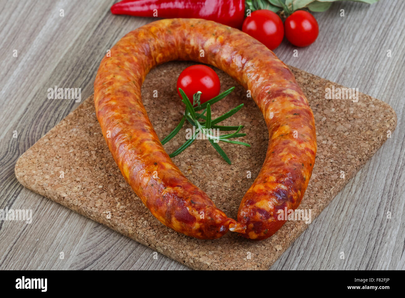 Sausage ring with rosemary and pepper on the wood background Stock ...