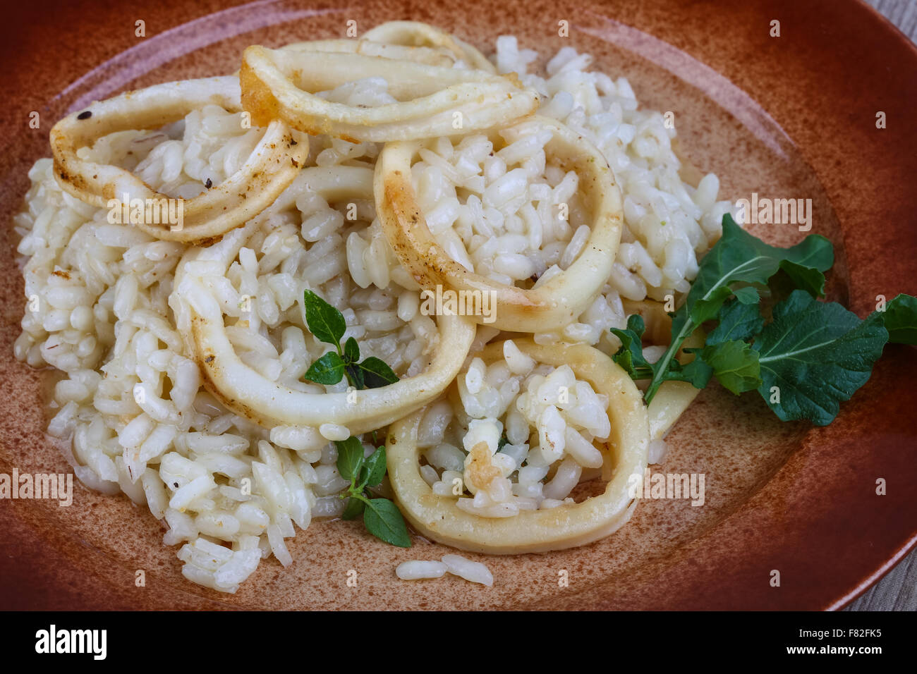 Italian famous cuisine - Squid risotto served basil leaves Stock Photo ...