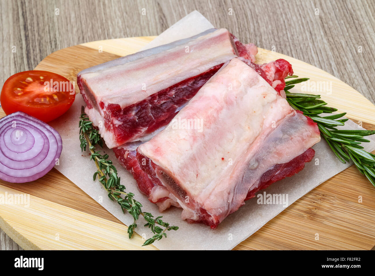 Raw Beef ribs with rosemary and thyme on wood background Stock Photo ...