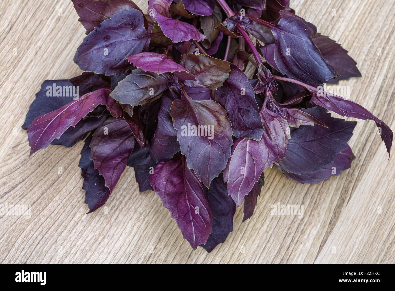 Fresh violet Basil leaves heap on the wood background Stock Photo - Alamy