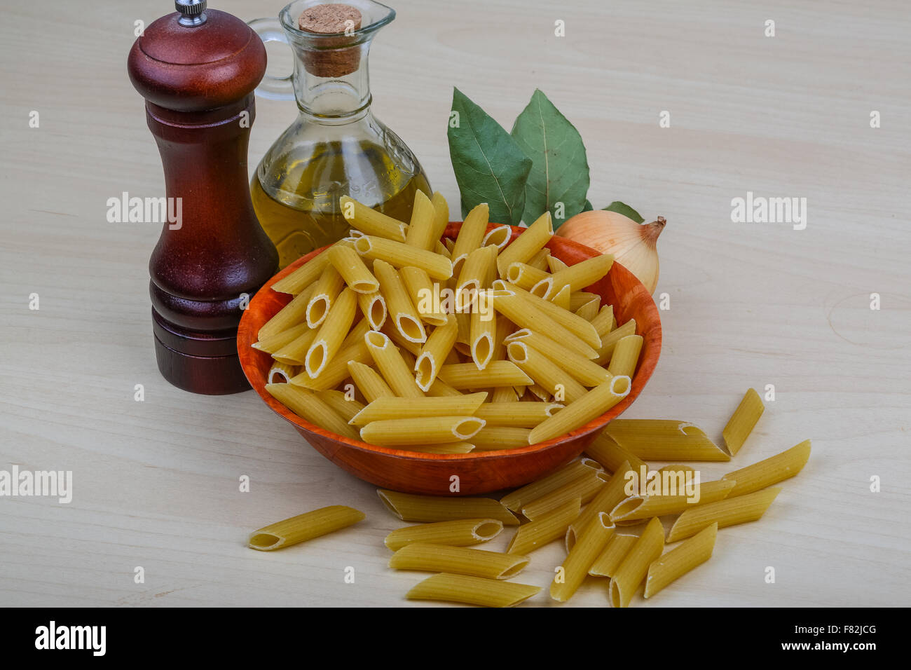 Raw penne in the bowl with olive oil Stock Photo - Alamy