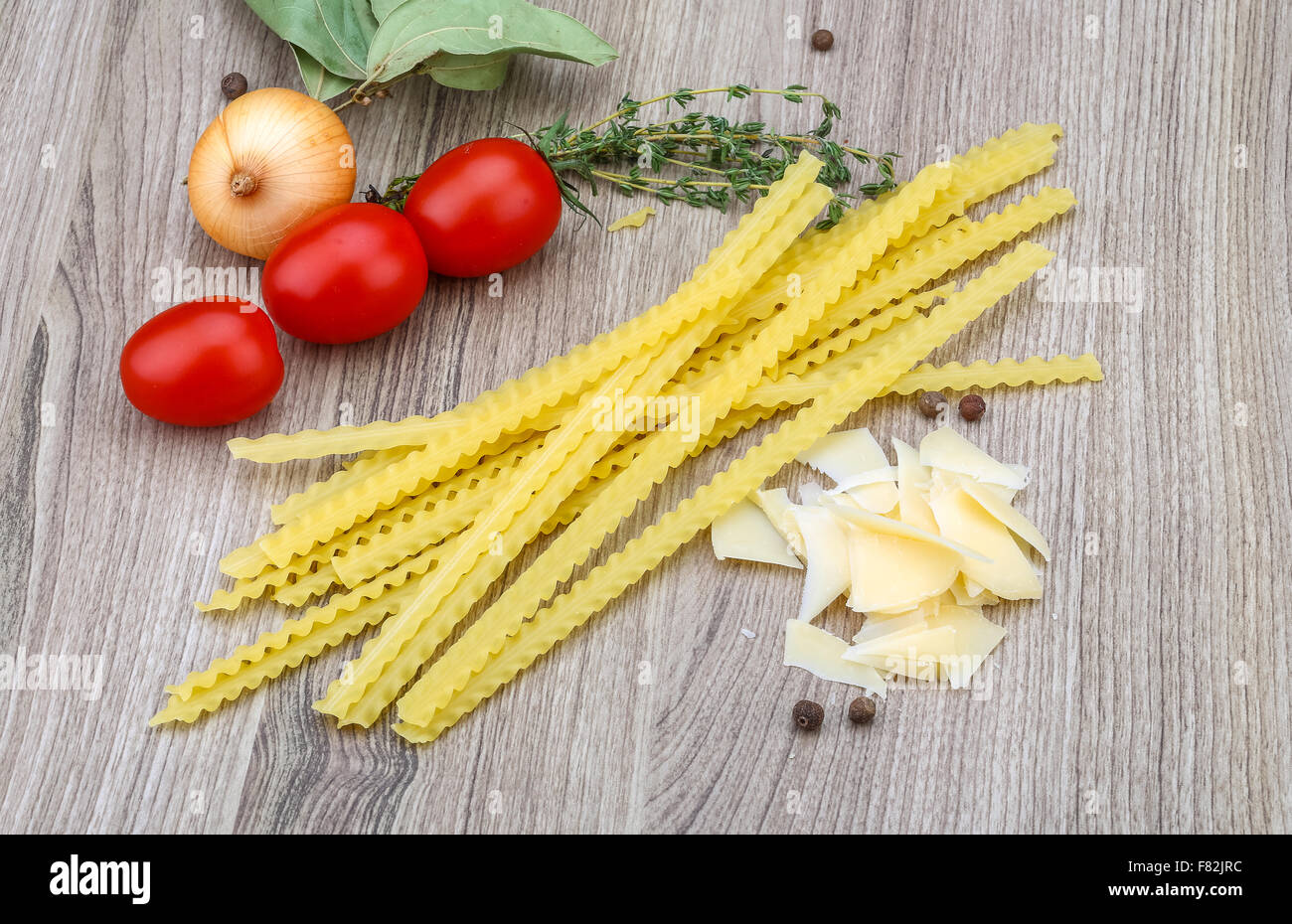 Raw Italian Mafalde pasta with tomatoes, onion and parmesan cheese ...