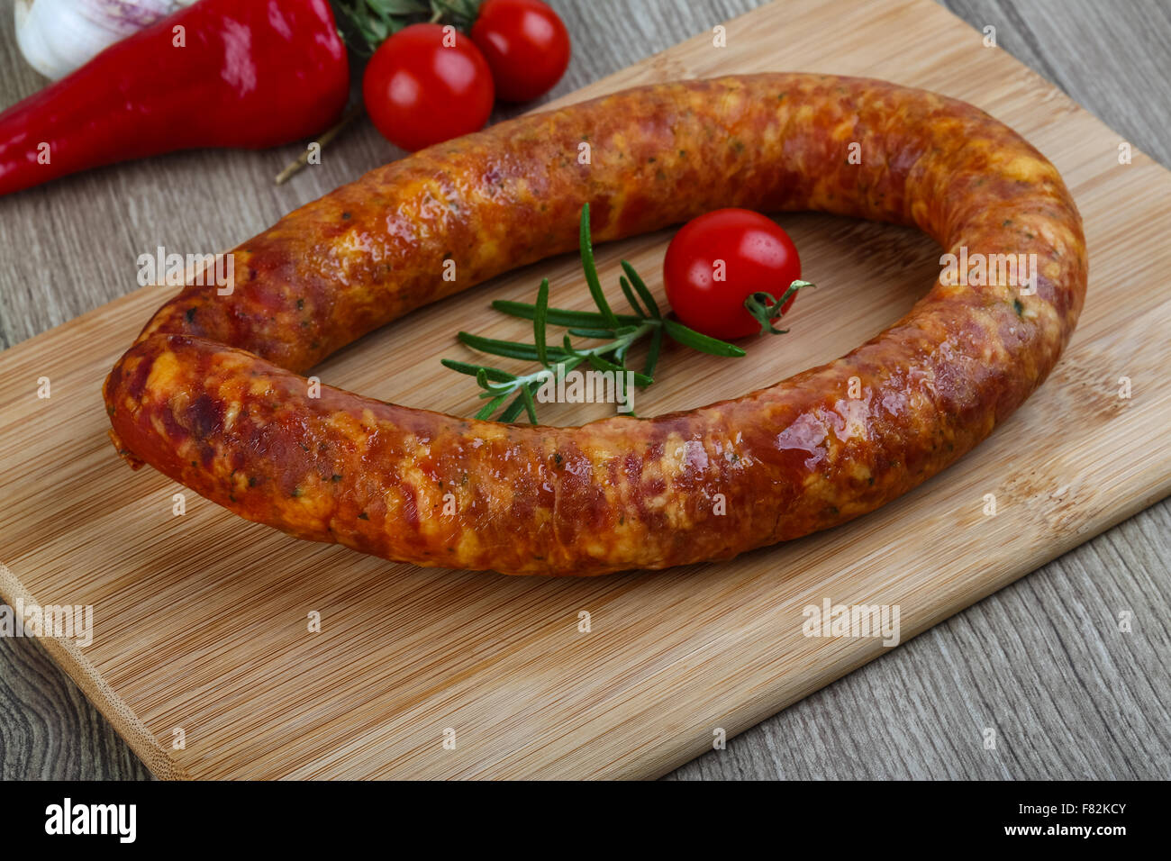 Sausage ring with rosemary and pepper on the wood background Stock ...