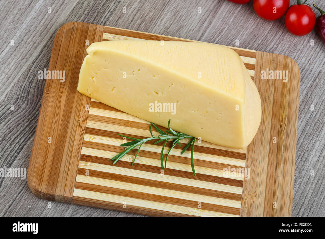 Yellow cheese triangle with rosemary herbs on the wood background Stock ...