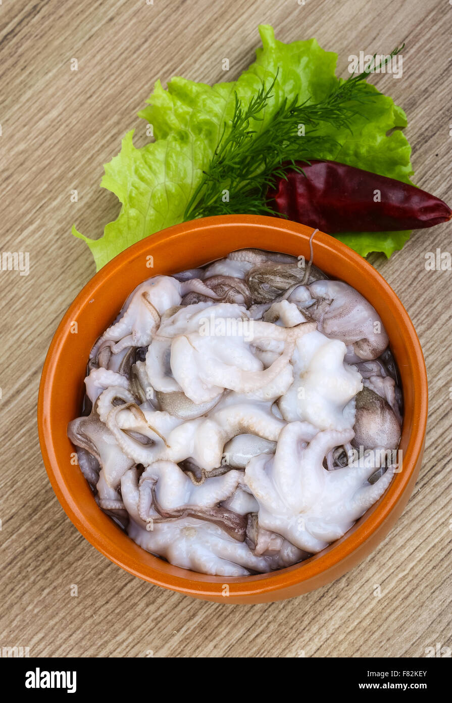 Raw baby octopus in the bowl ready for cooking Stock Photo - Alamy