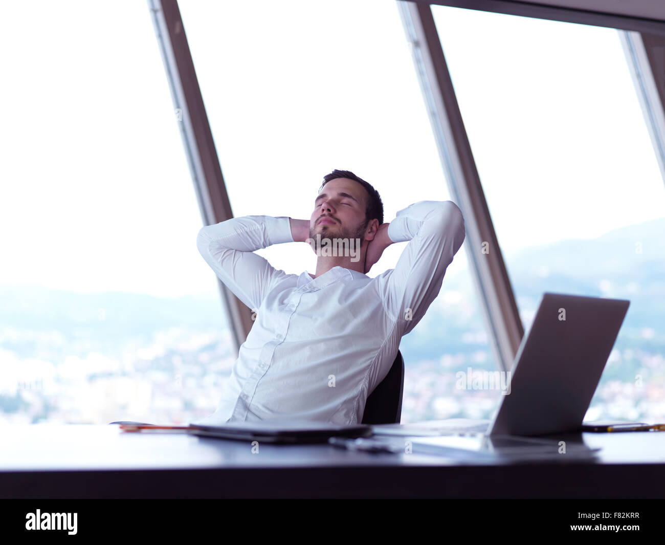 happy young business man work and relax at modern bright office ...