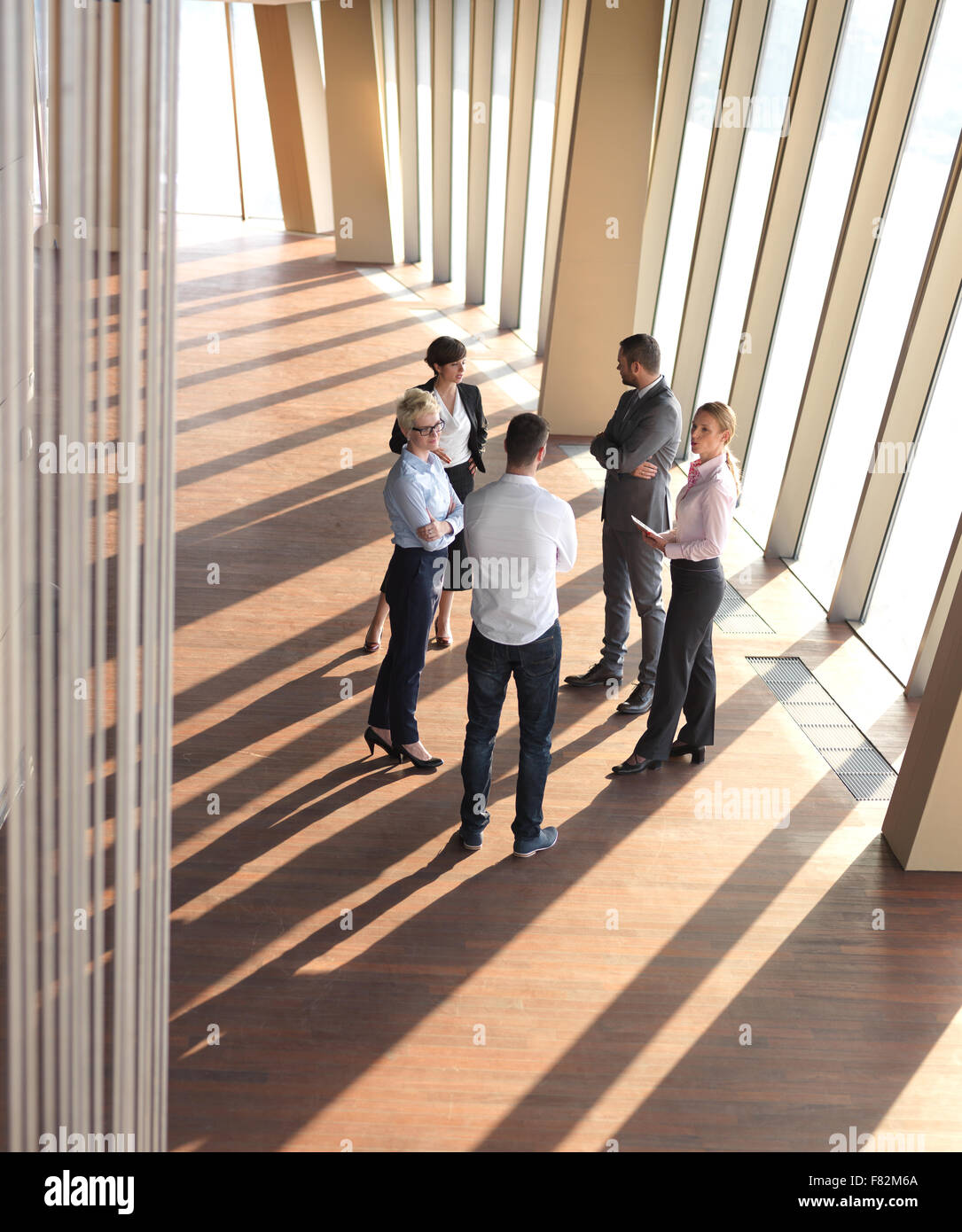 business people group standing together as team by window in modern ...